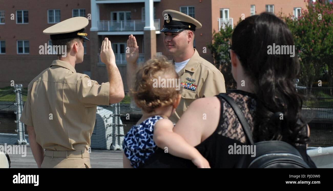 Family members watch a re-enlistment ceremony for FCC(SW) Robert J ...