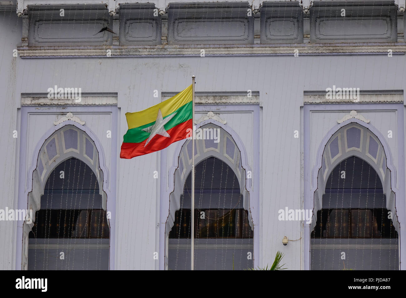 Myanmar national flag with old building (Yangon City Hall) background ...