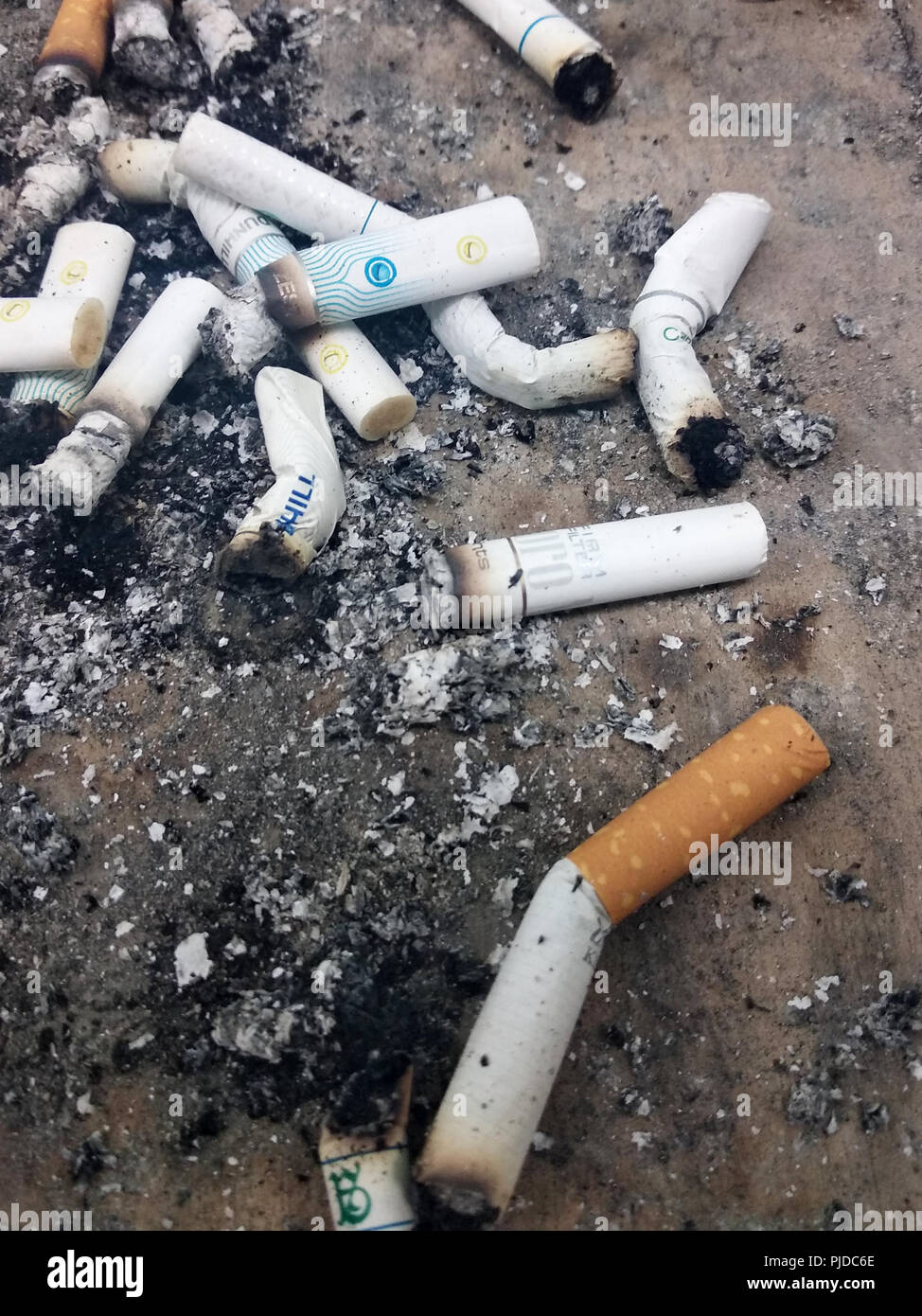 Used cigarettes butt in dirty big wooden box ashtray Stock Photo - Alamy