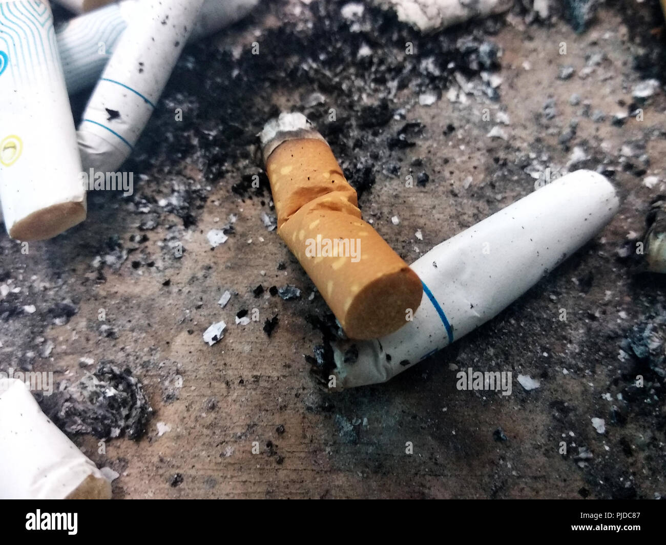 Used cigarettes butt in dirty big wooden box ashtray Stock Photo - Alamy
