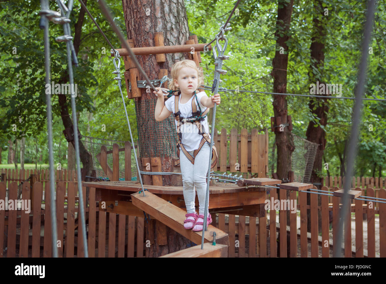 Portrait of little girl in cable car park. She passes the obstacle ...