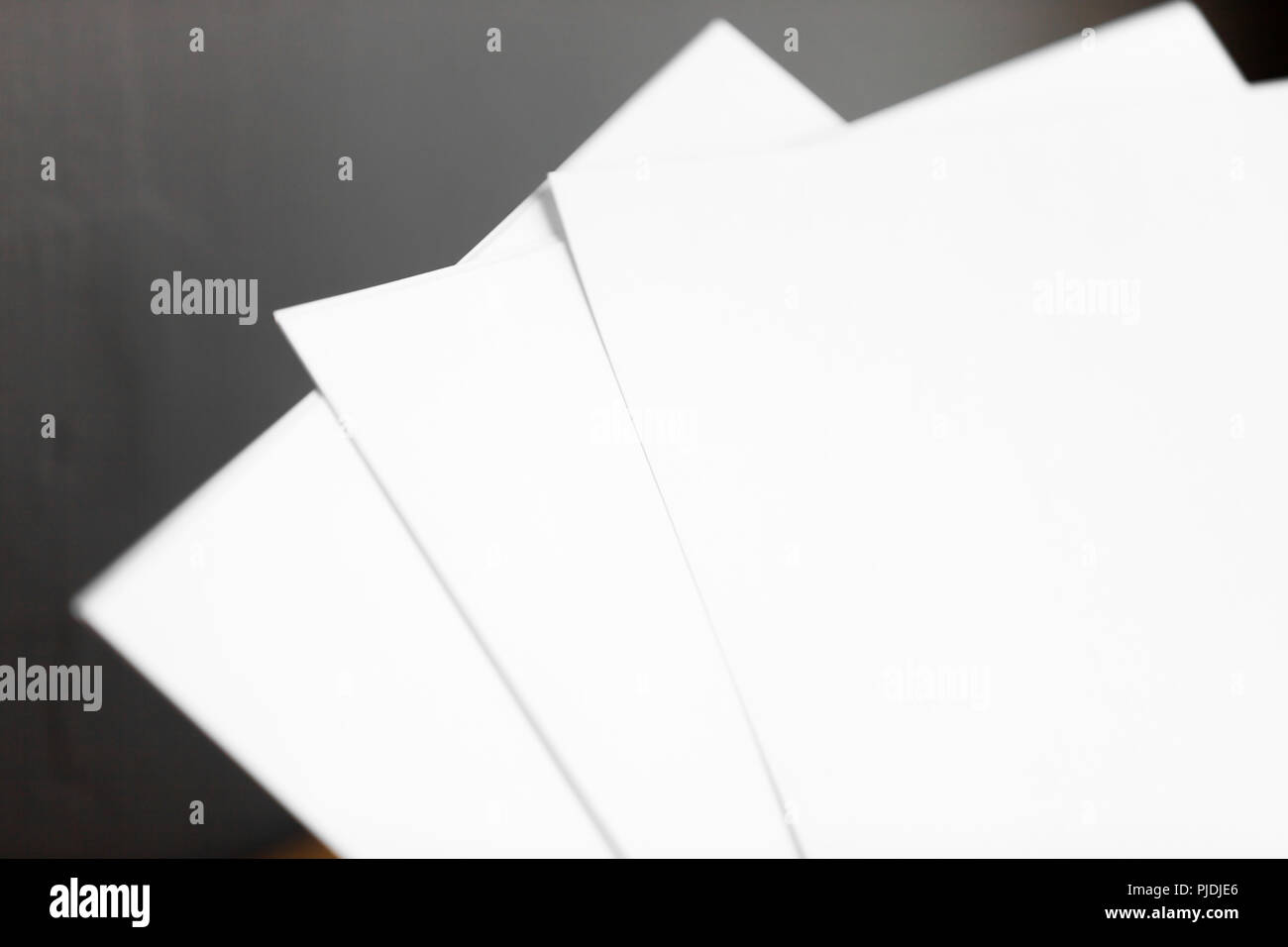 Three individual white pages sorted against dark textured wall Stock ...