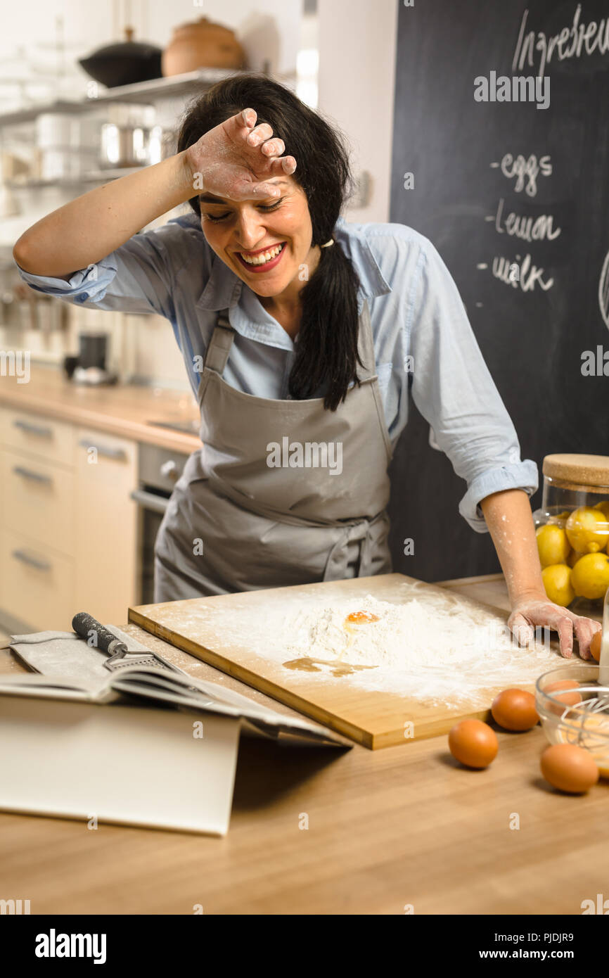 checking recipe in cookbook. Woman preparing american pie Stock Photo ...