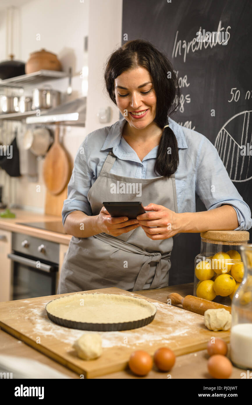 Checking online recipe for sweet berry pie Stock Photo - Alamy