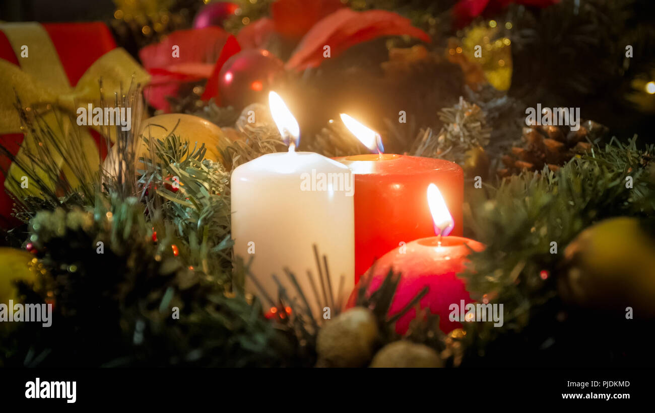 Closeup image of three burning candles and beautiful Christmas wreath ...