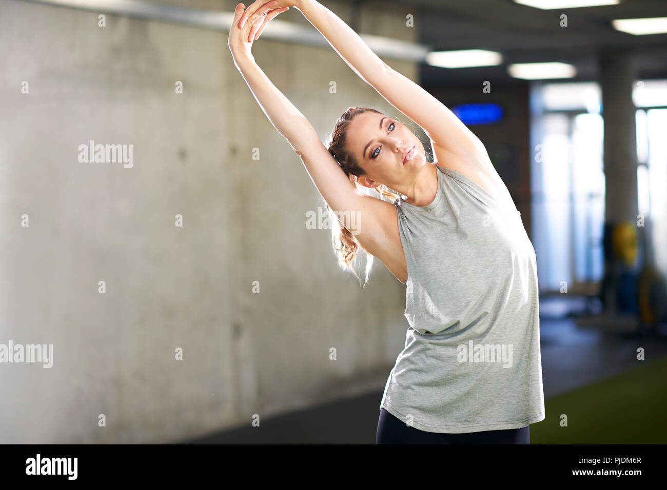 Woman doing stretching exercise in gym Stock Photo - Alamy