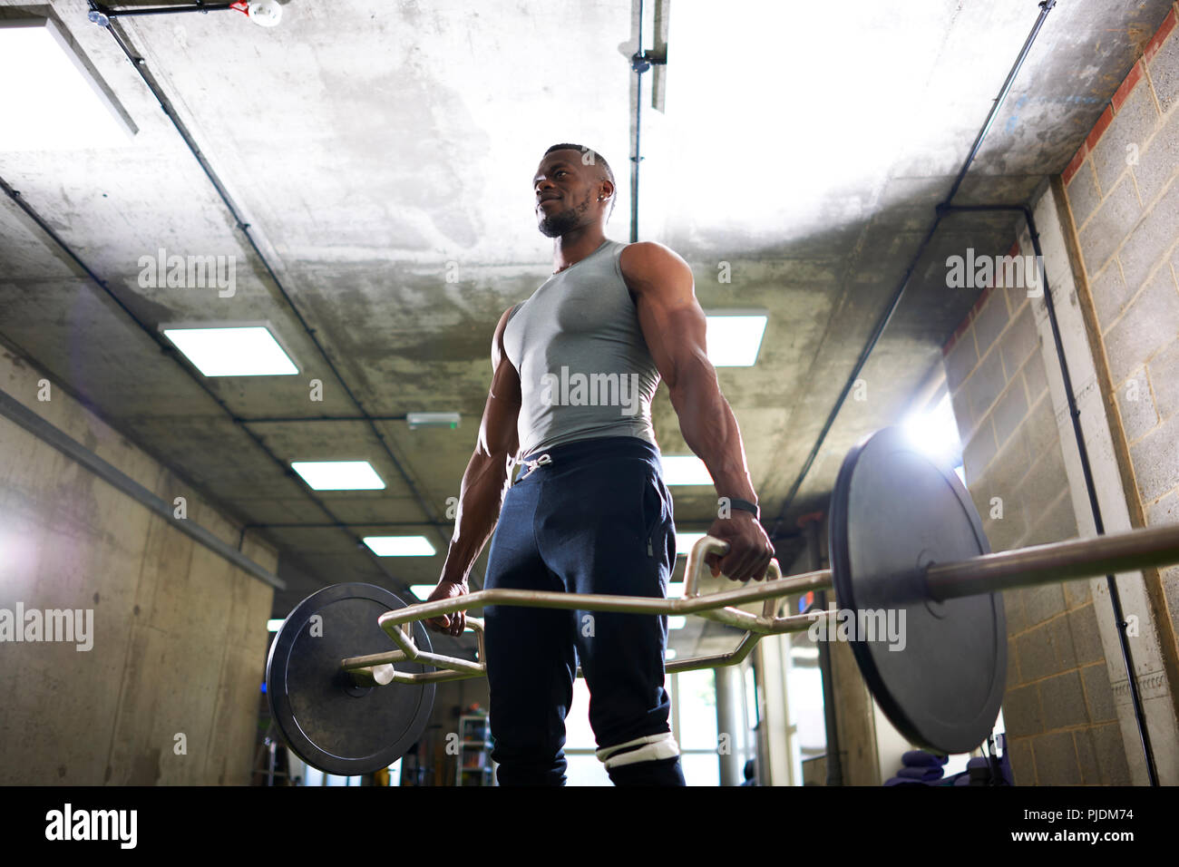 Man lifting barbell in gym Stock Photo - Alamy