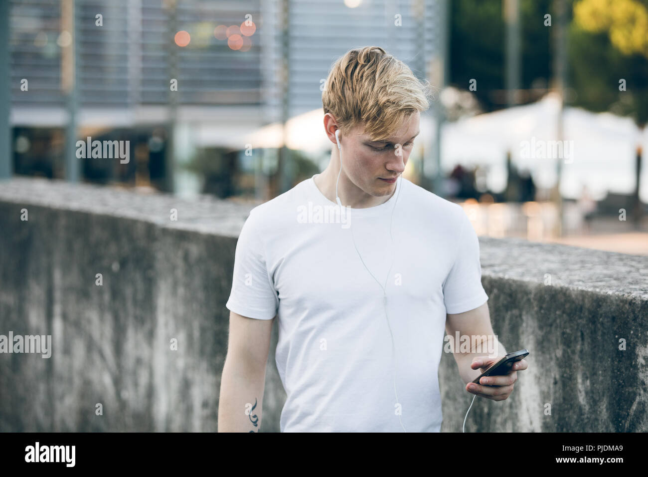 Young man using mobile outdoors hi-res stock photography and images - Alamy