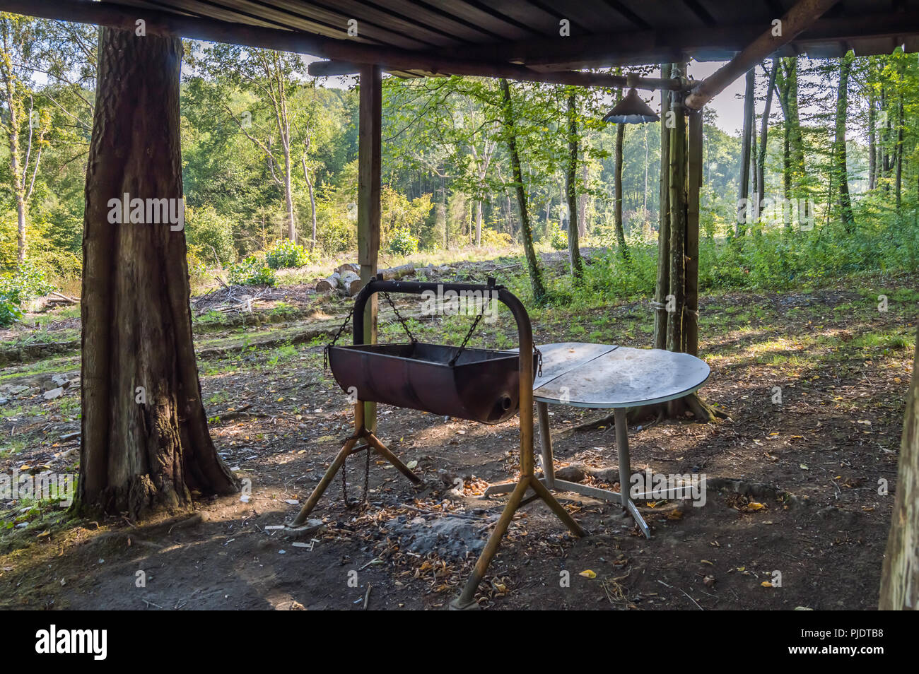 Hanging barbecue made with an old barrel under a wooden roof in the ...