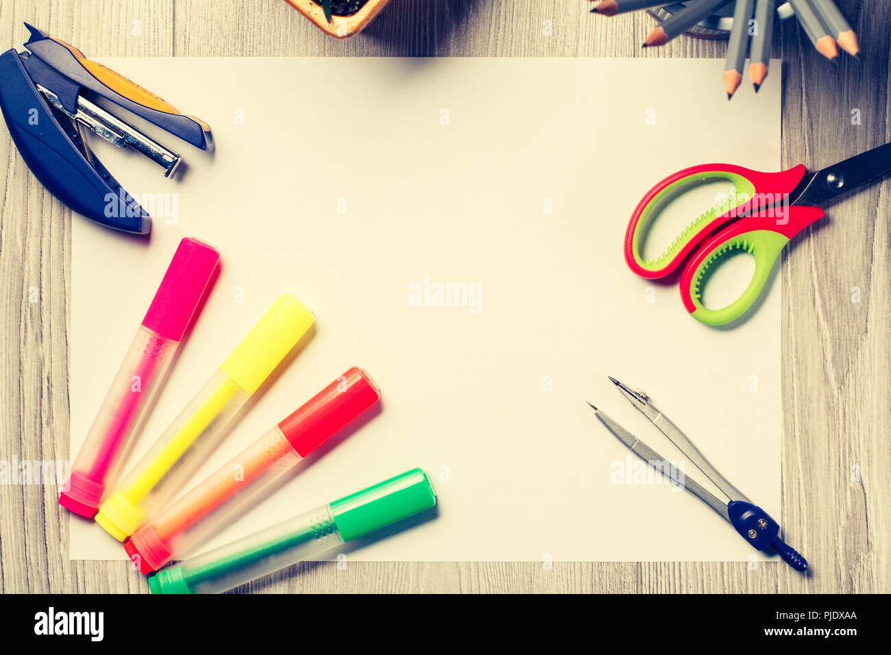 Color felt pens, stapler, compass, scissors and pencils on grey wooden ...