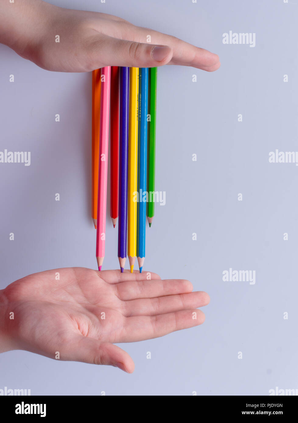 Hand holding color Pencils placed on a white background Stock Photo - Alamy