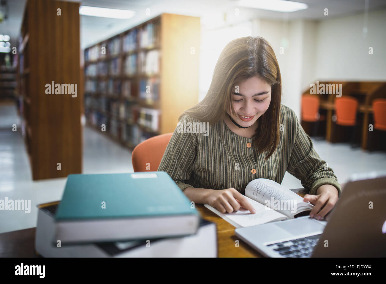 Young women reading and using labtop computer in the library Stock ...