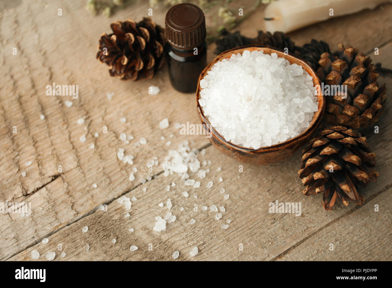 Spa and wellness setting with sea salt, oil essence, cones and candle ...