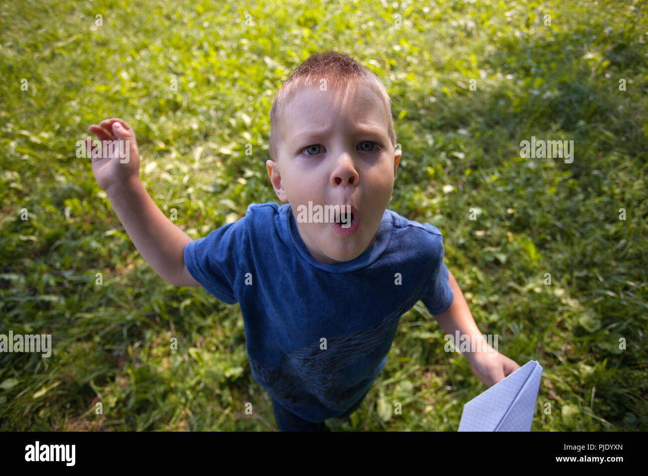 Cute caucasian child playing paper airplane in the park outdoors in ...