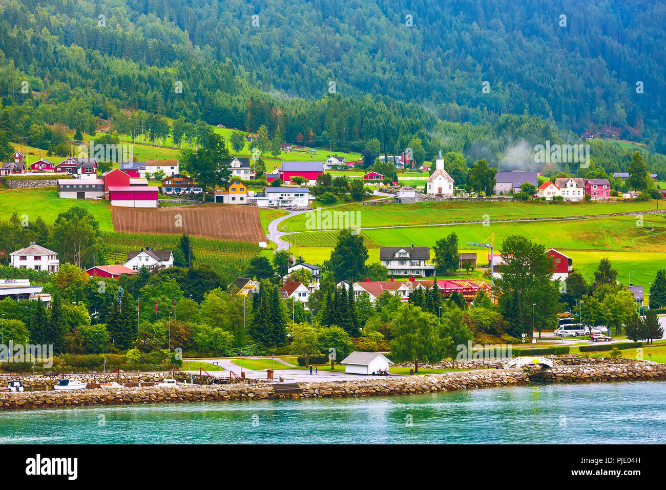 Norwegian village landscape with turquoise fjord water, mountains ...