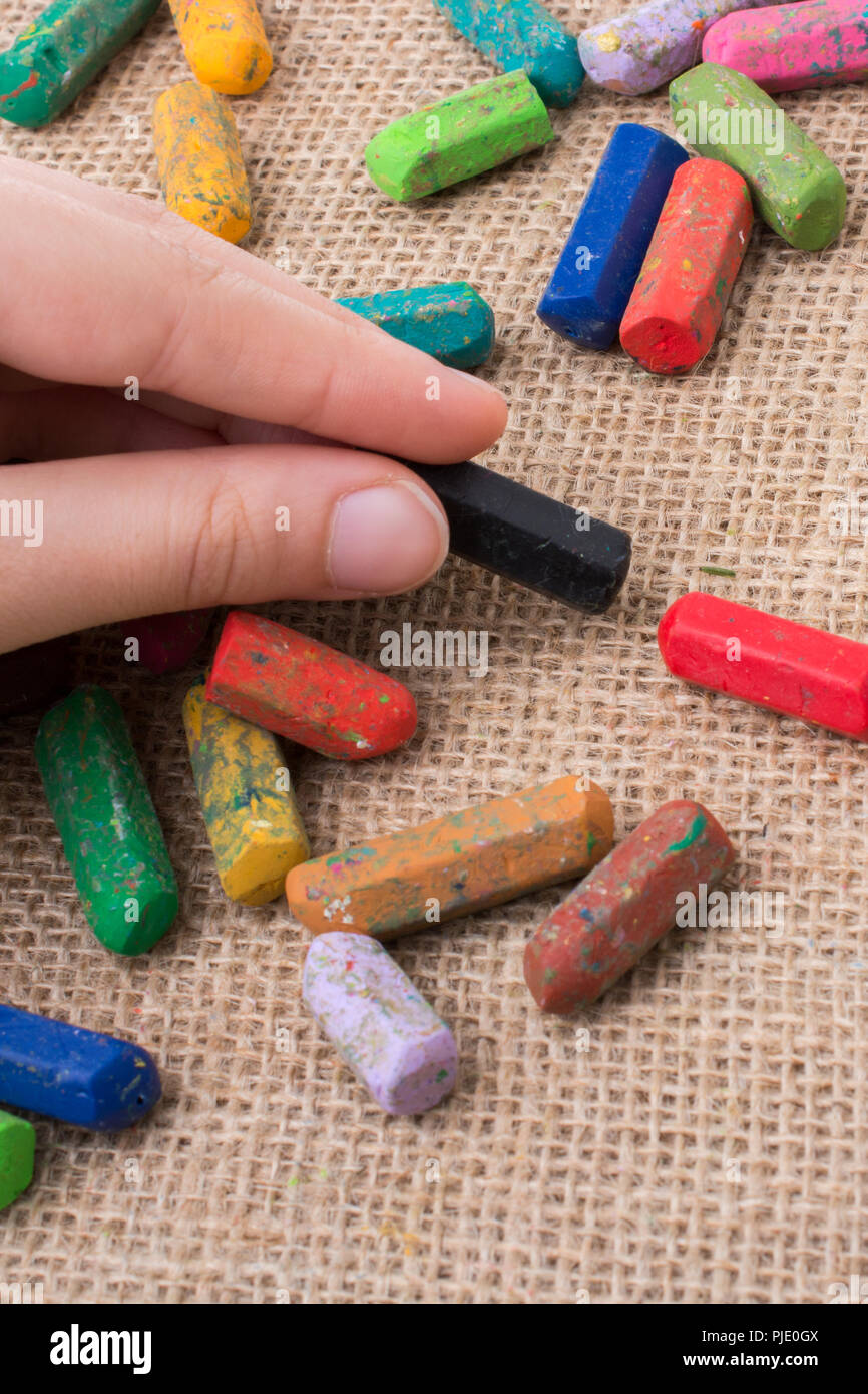 Used color crayons and a hand holding one Stock Photo - Alamy
