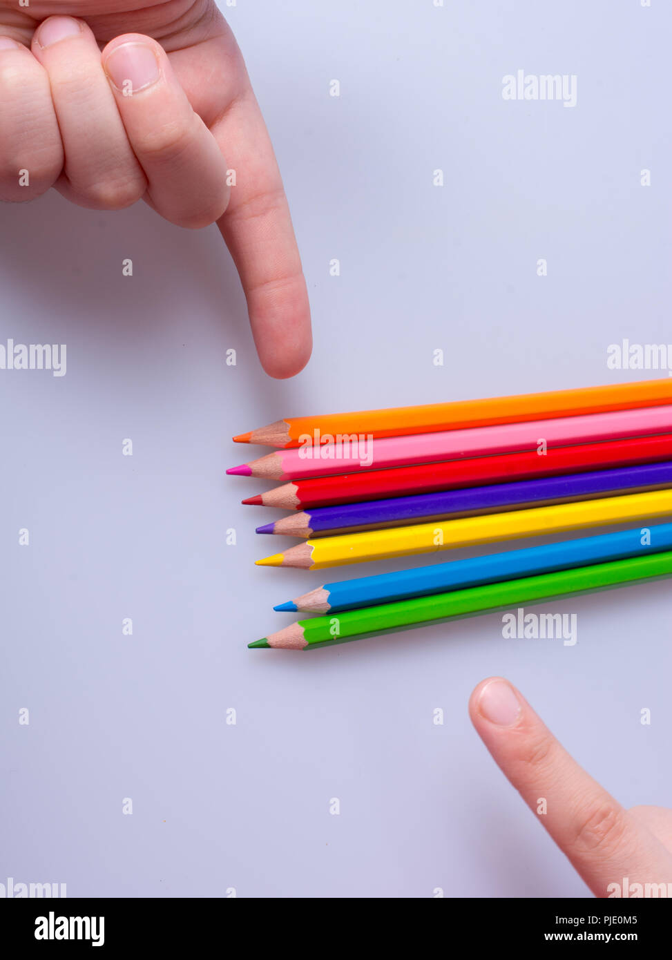 Hand holding color Pencils placed on a white background Stock Photo - Alamy
