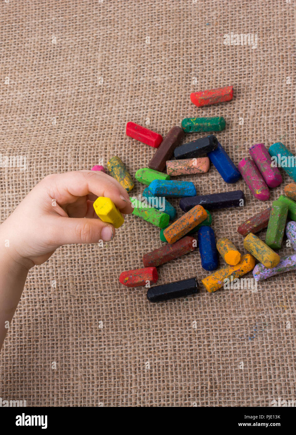 Used color crayons and a toddlers hand holding one Stock Photo - Alamy