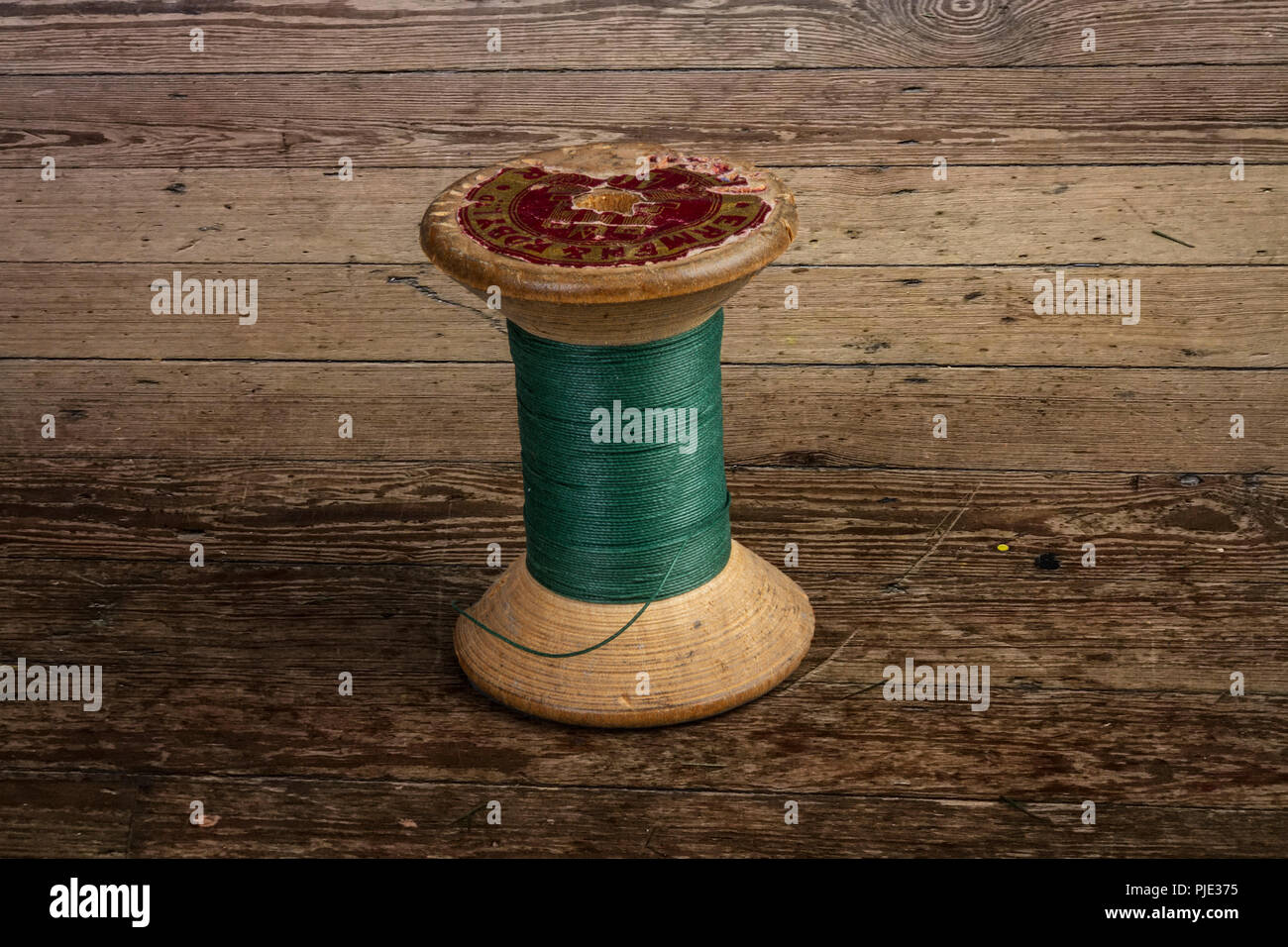 Cotton reel with green cotton Stock Photo - Alamy