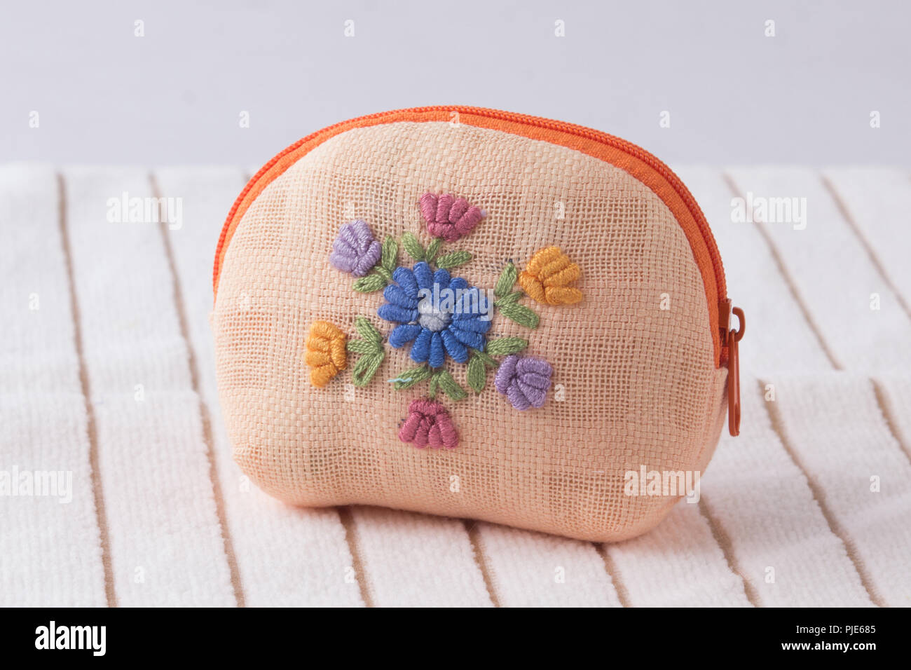 Fabric coin purse with flowers embroidery on white cloth background ...