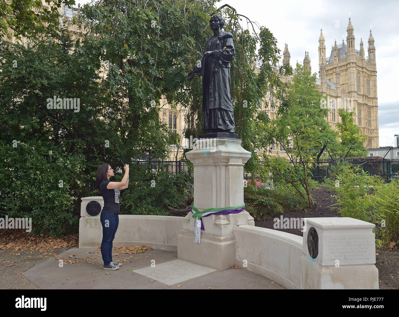 A woman takes a picture of the statue of suffragette leader Emmeline ...