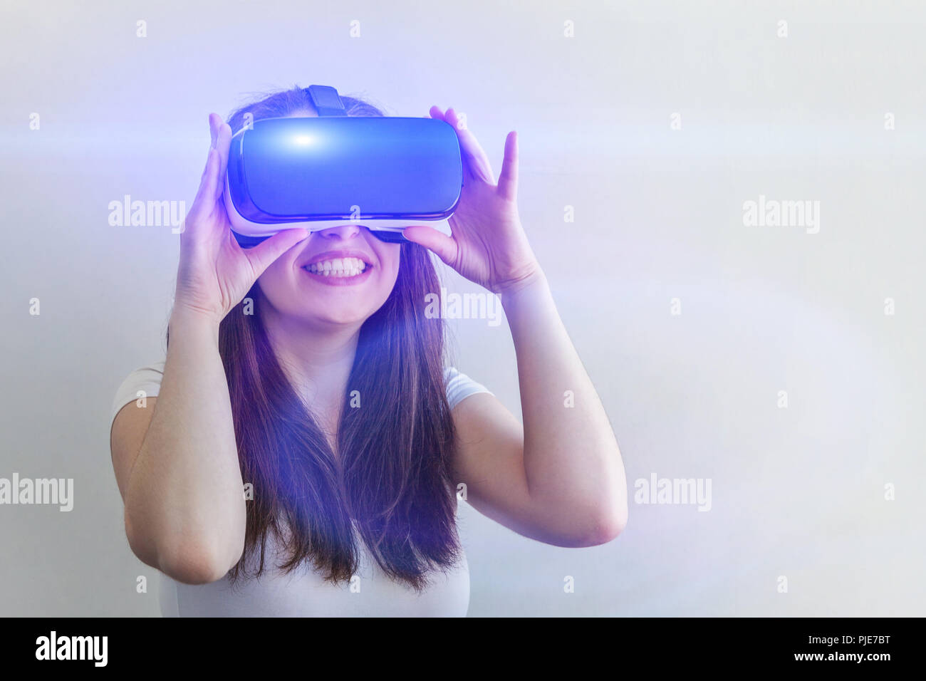 Smile young woman wearing using virtual reality VR glasses helmet ...