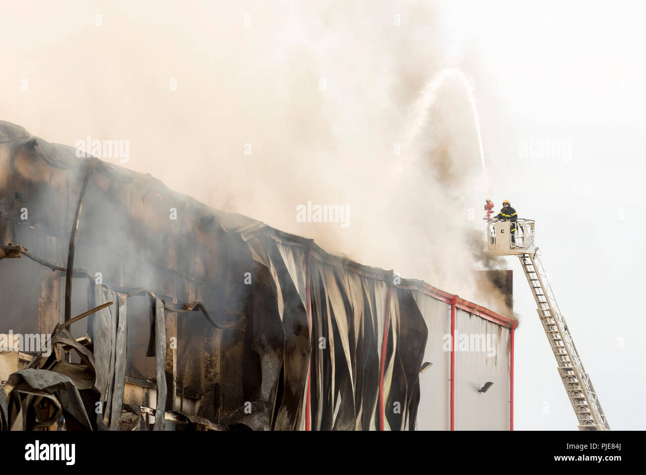 Fire disaster in a warehouse. Fire fighting in an industrial area Stock ...