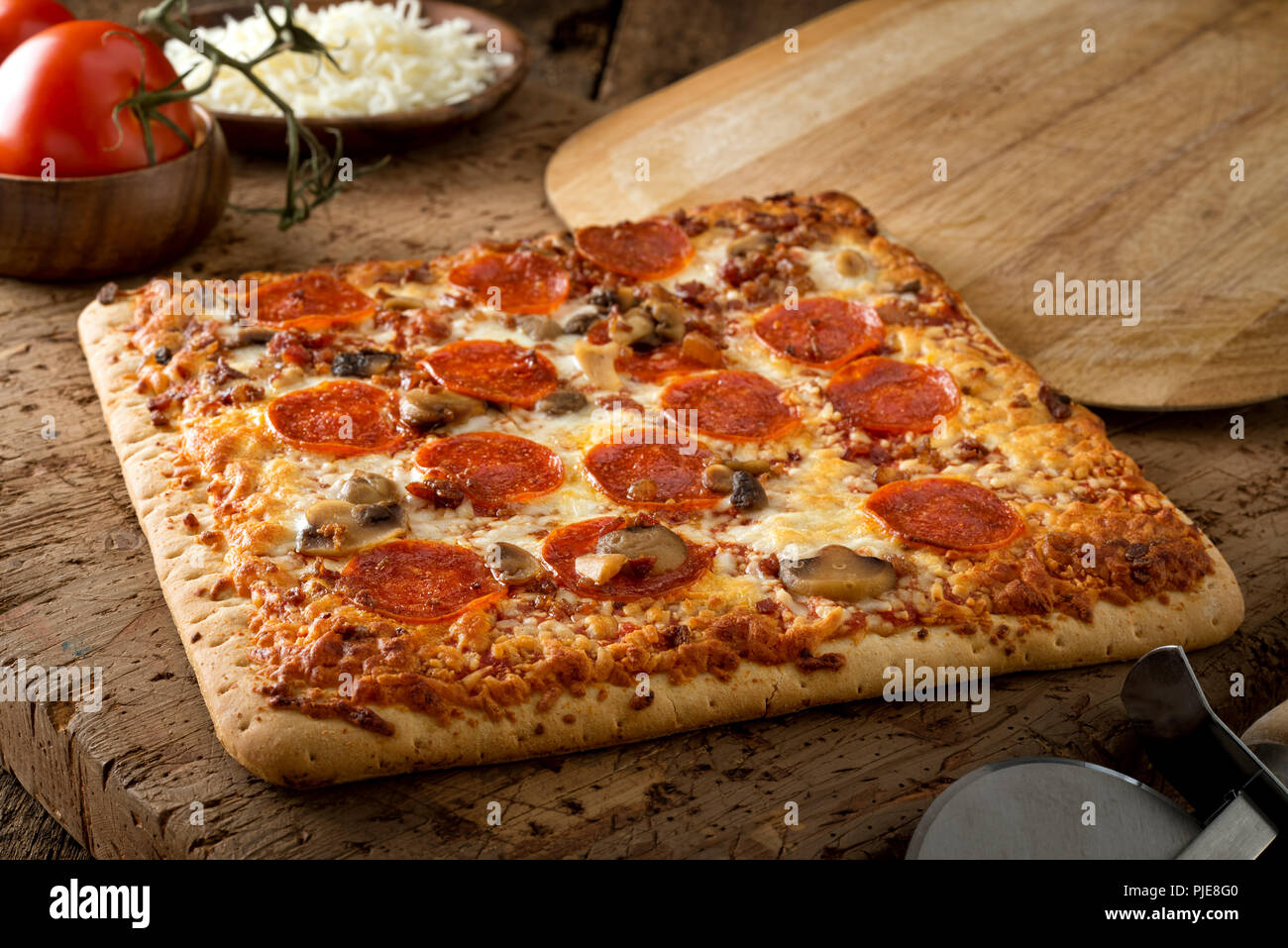 A delicious square crust flatbread pizza with pepperoni, bacon and ...