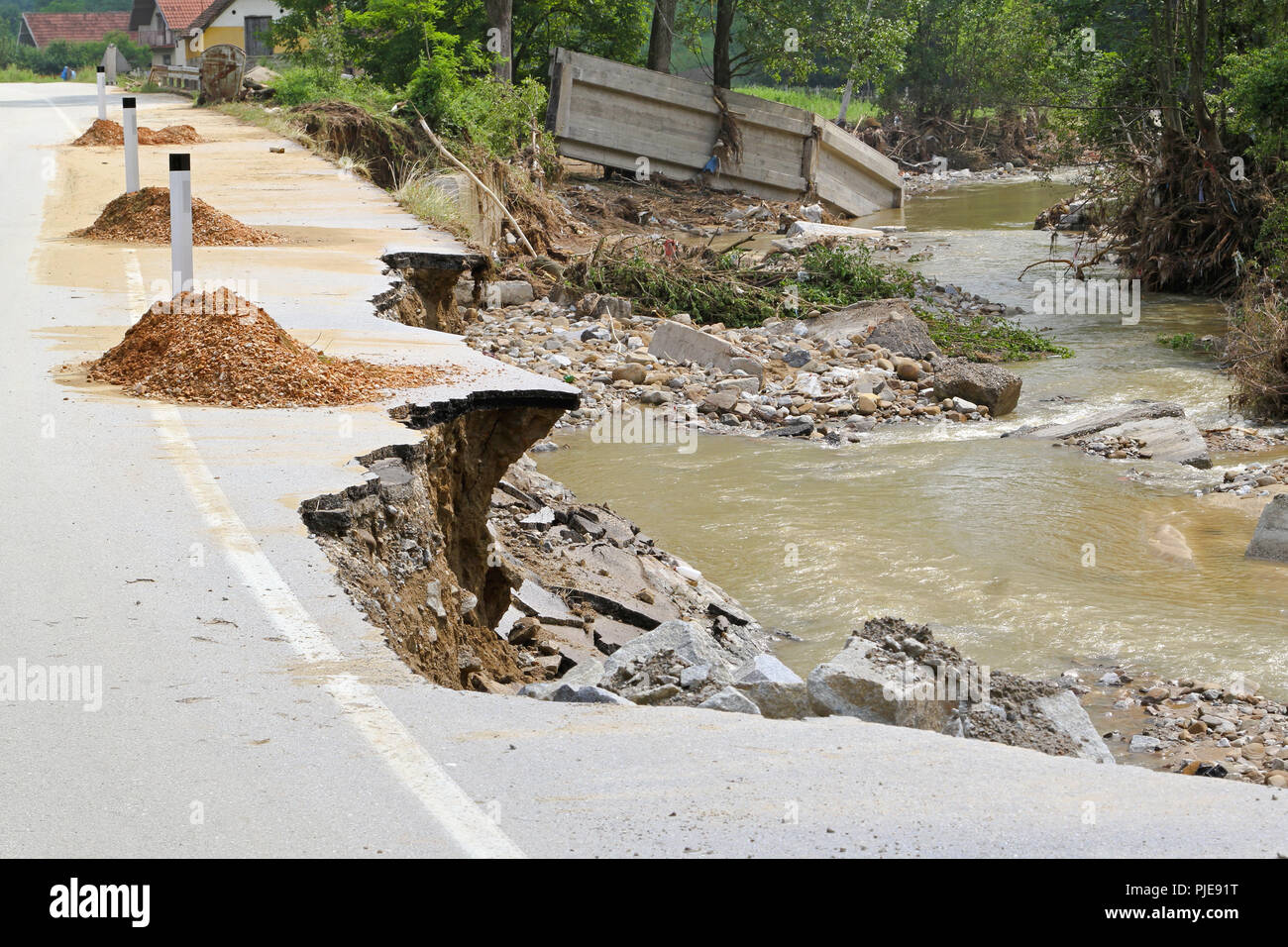 Destroyed road left with debris after river flooding Stock Photo - Alamy