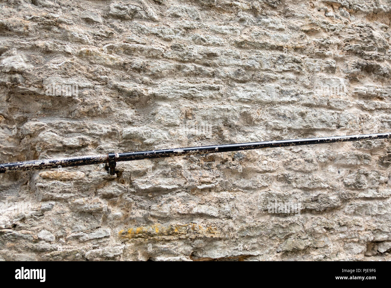 Old metal rail on a ancient stone wall Stock Photo - Alamy
