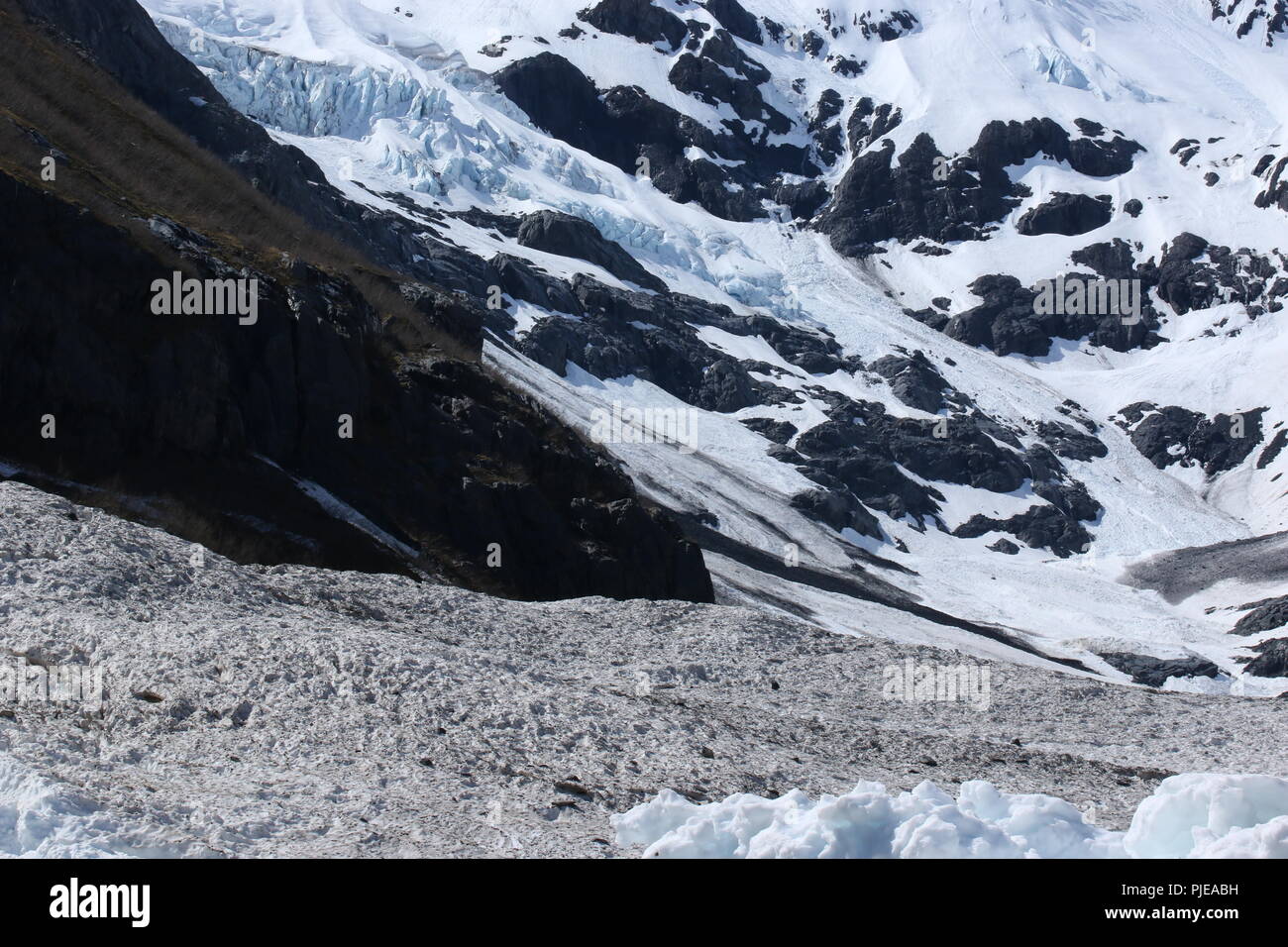 A huge field of snow collects in the crevice between two mountains ...