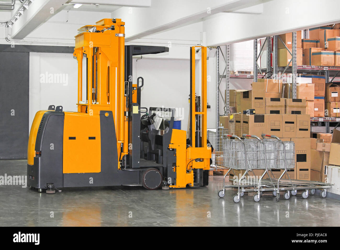 Electric forklift stacker in warehouse with boxes Stock Photo - Alamy