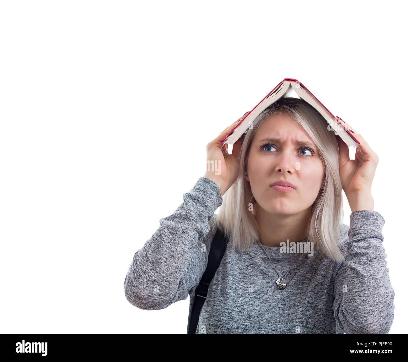 Confused young woman student holding a opened book over head isolated ...