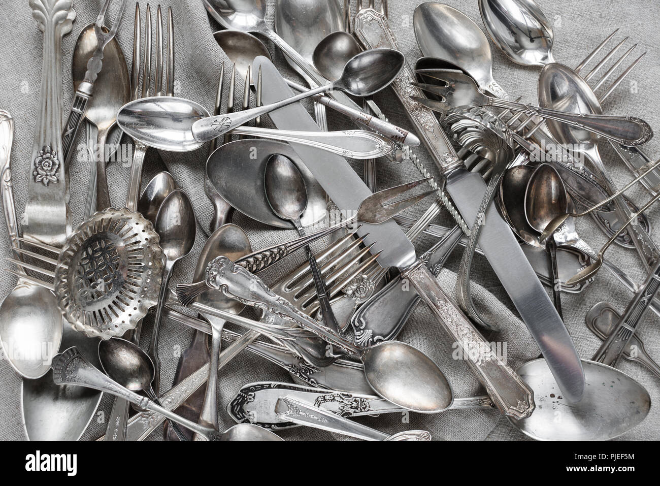 Various silverware on a background of gray linen fabric Stock Photo - Alamy
