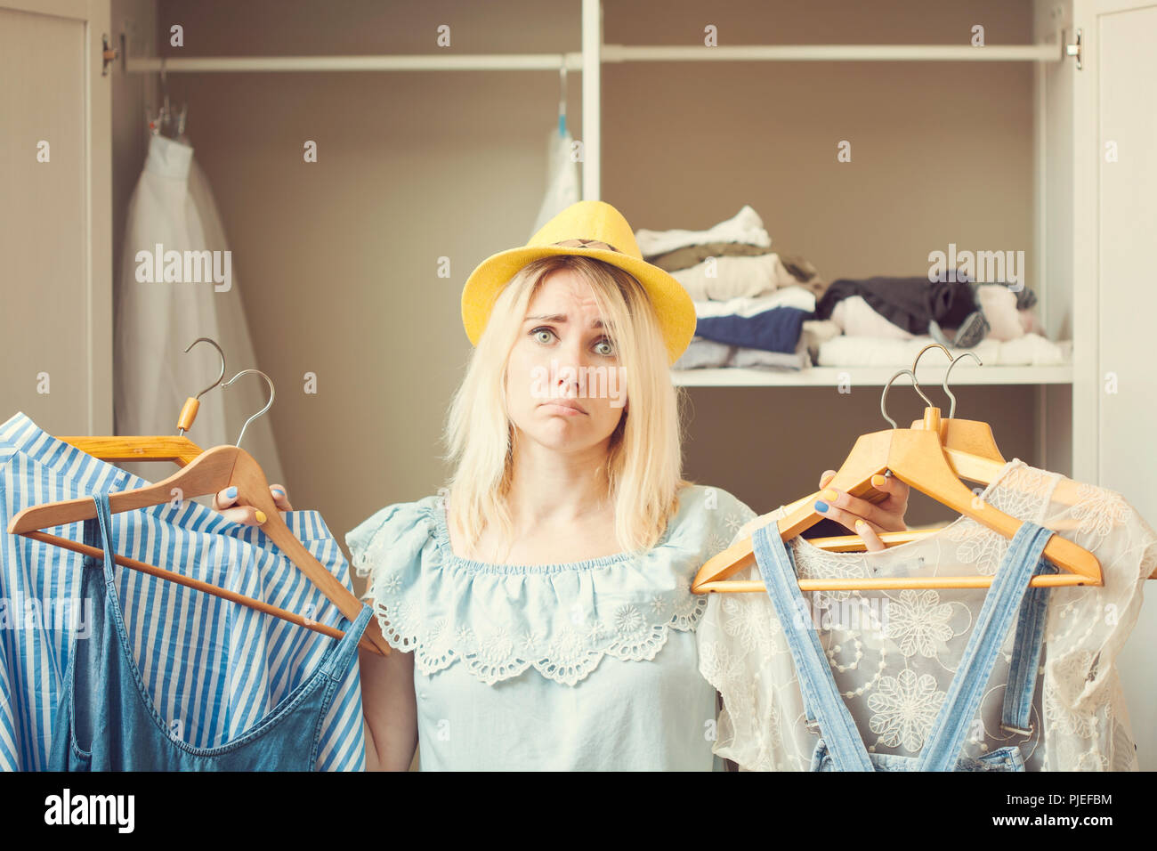 girl near a wardrobe with clothes can not choose what to wear. Heavy ...