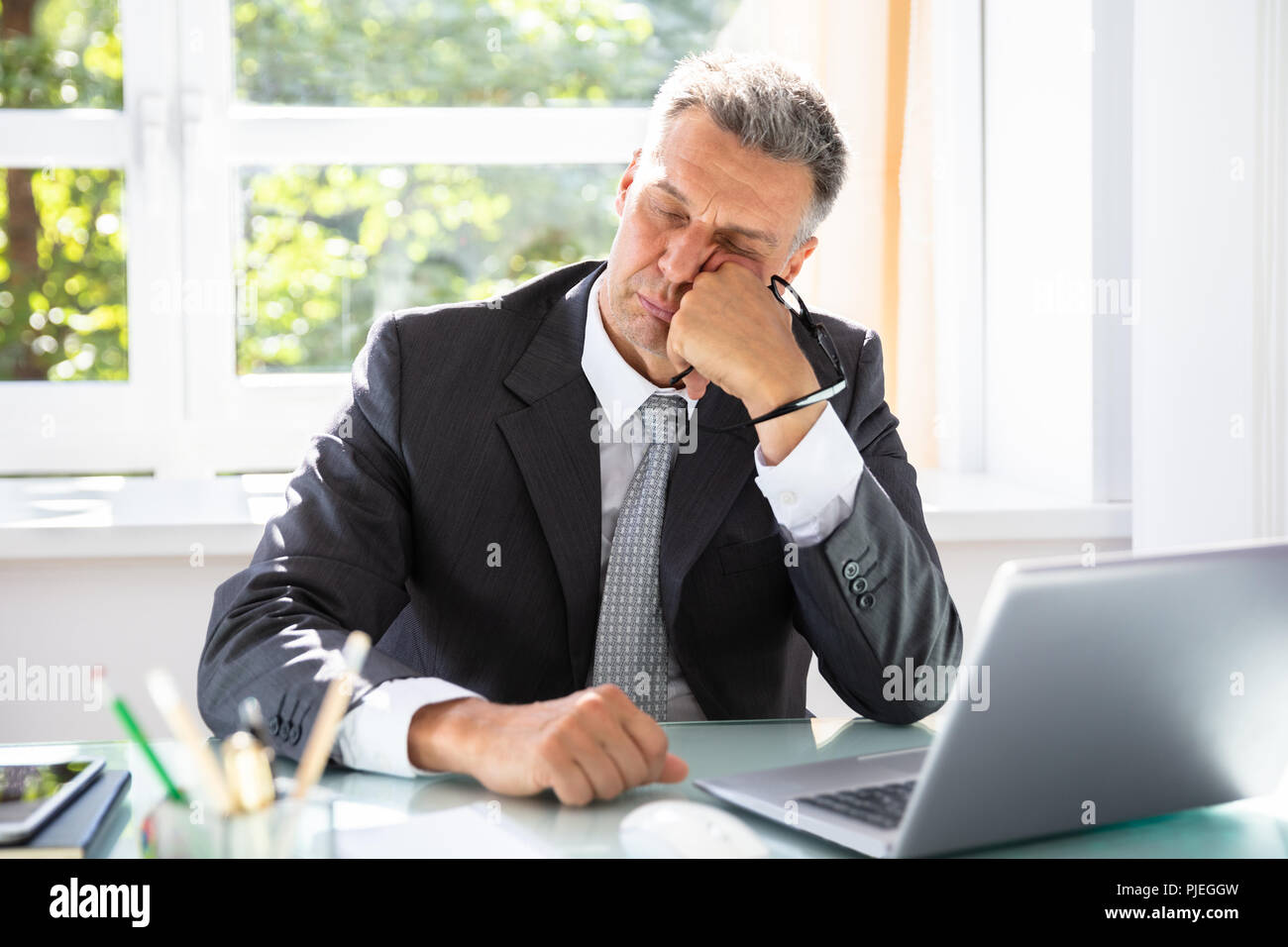 Photo Of Tired Mature Businessman Sleeping In Office Stock Photo - Alamy