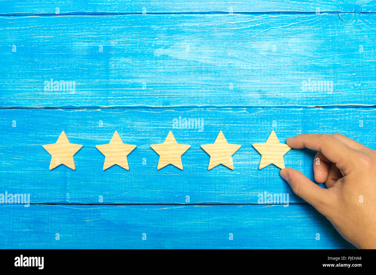 The businessman's hand in the suit holds the fifth star. Get the fifth ...