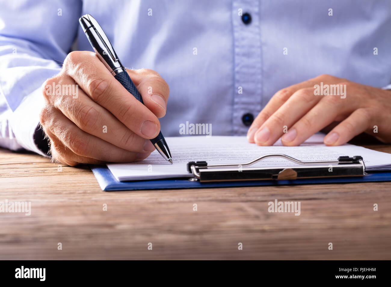 Men at a table signing papers hi-res stock photography and images - Alamy