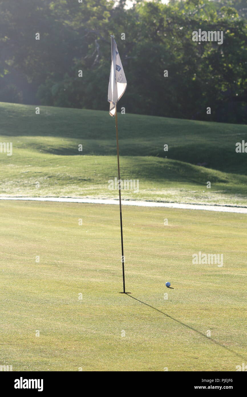 Golf ball and pin on the 10th hole green at Playa Dorada golf course ...