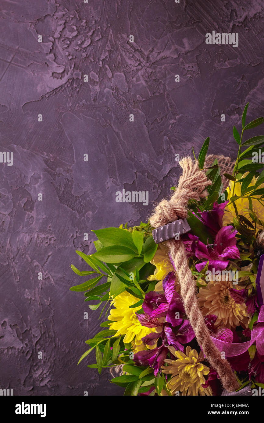Dark concrete background with colorful flowers on it with copy space ...