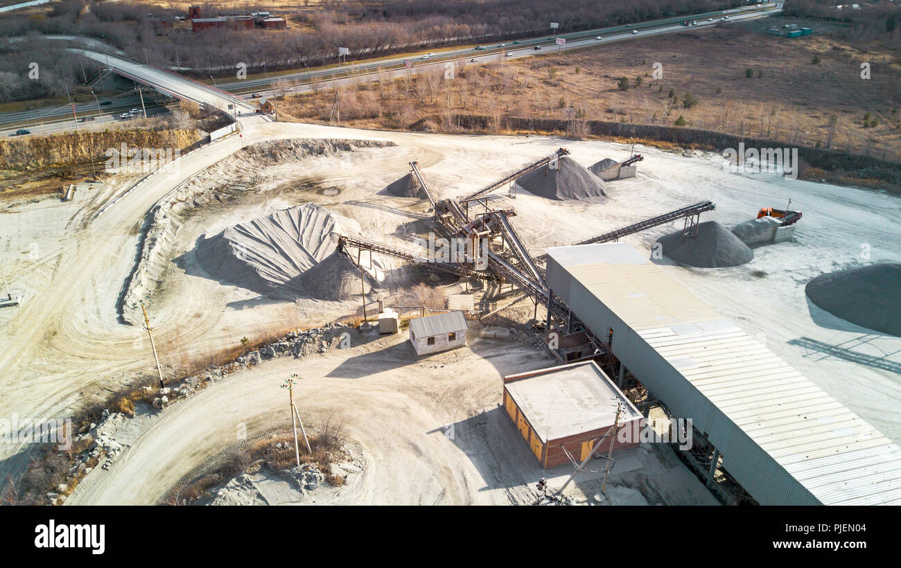 Aerial view of opencast mining quarry with of machinery at work, white ...
