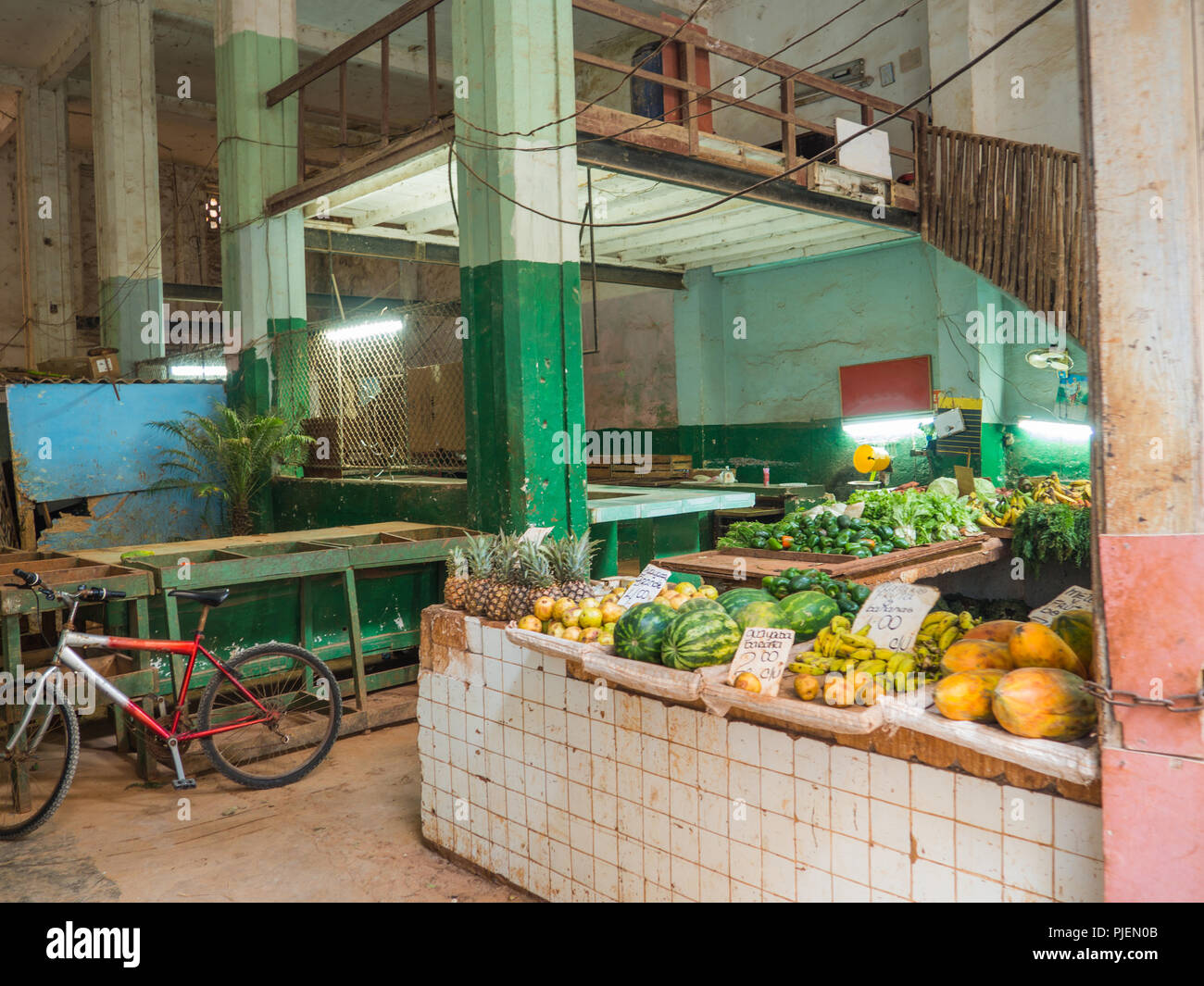 View of small fruit and vegetable market in an old dilapidated building ...