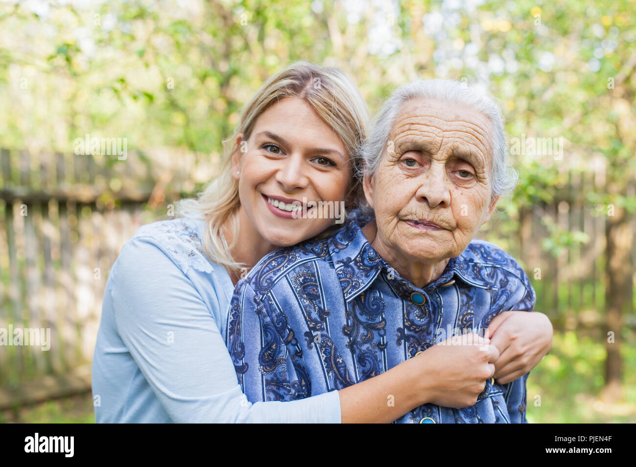 Young cheerful woman hugging her sick grandmother outdoor Stock Photo ...