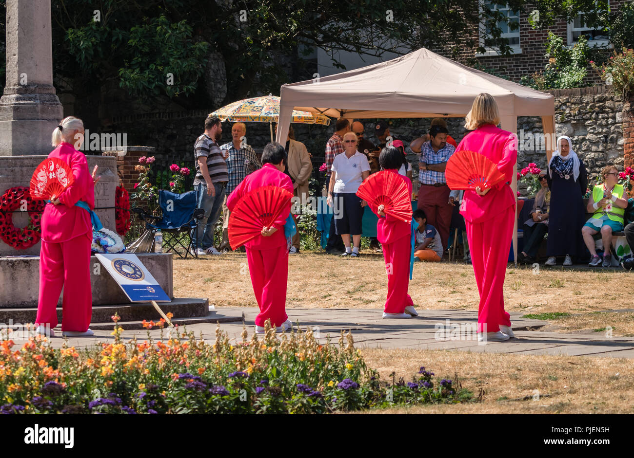 Rochester, England - July 2018 : A group of women with red fans ...
