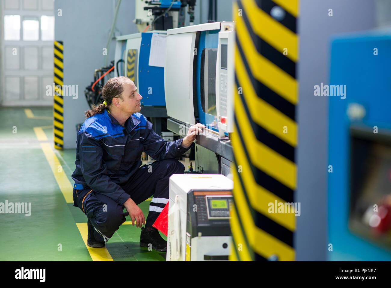Factory worker working on a factory machine Stock Photo - Alamy