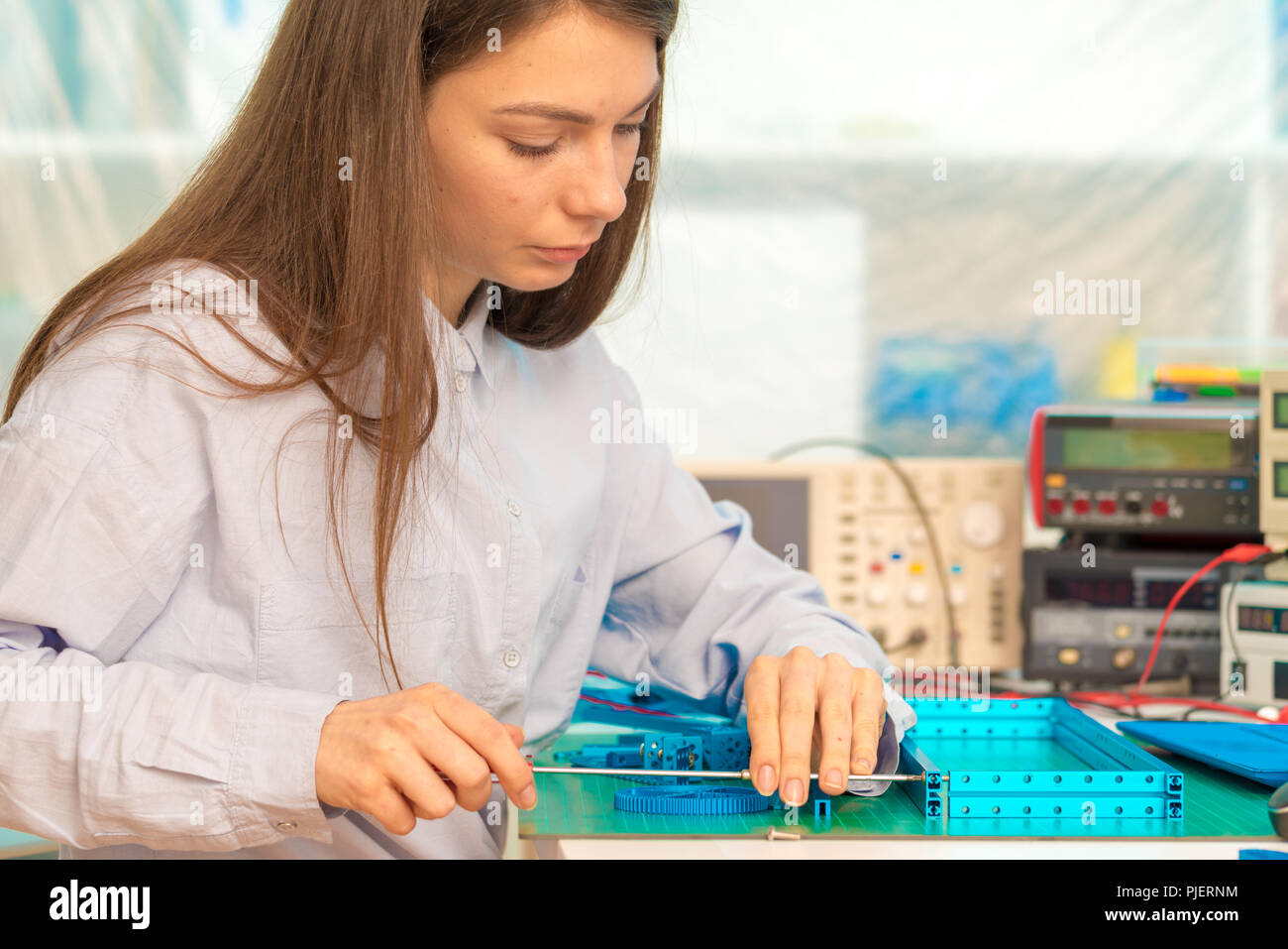 Female student in electronics class uses a Measuring device Stock Photo ...