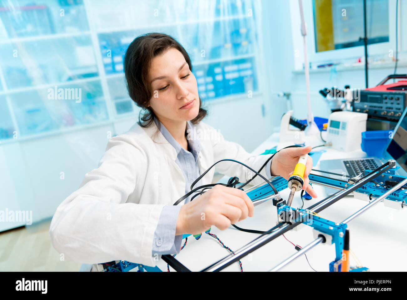 Student girl in electronics laboratory, experiment with microcontroller ...