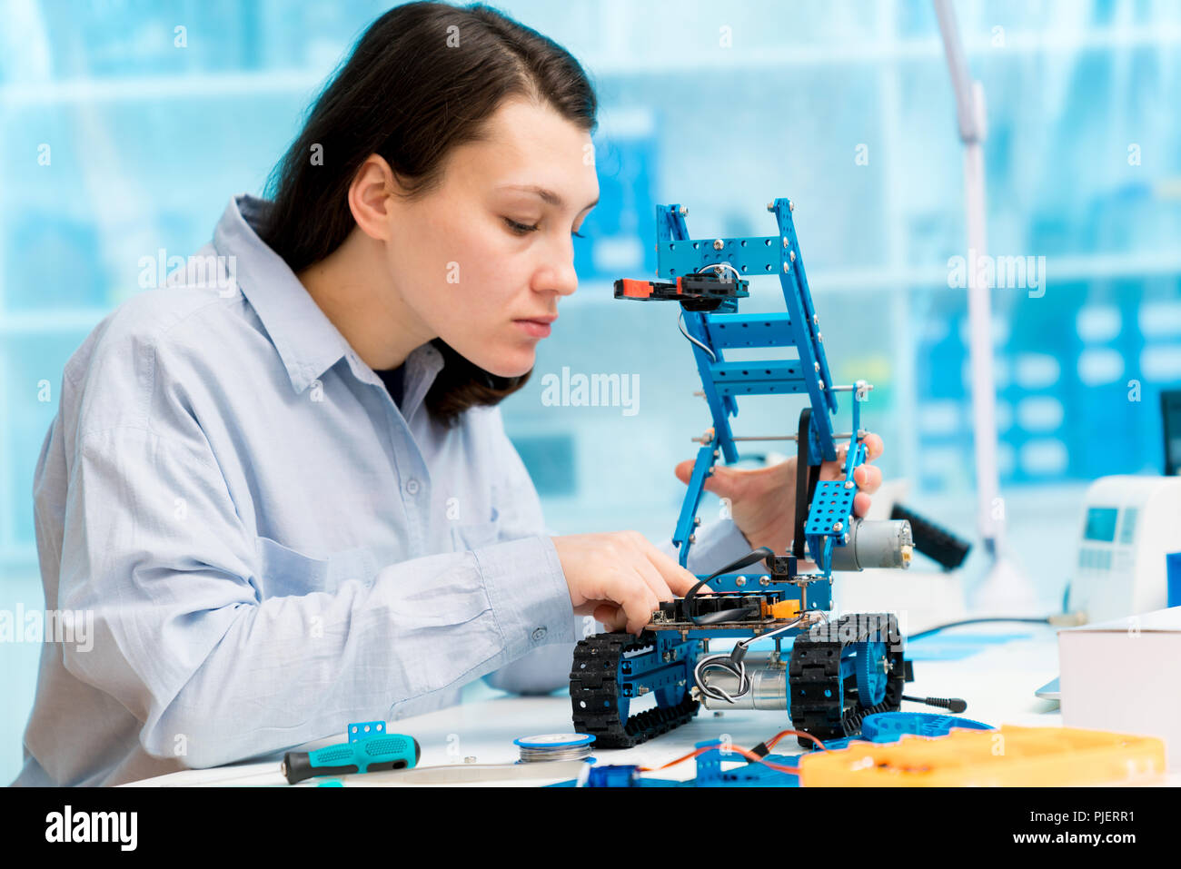 Student girl in electronics laboratory, experiment with microcontroller ...