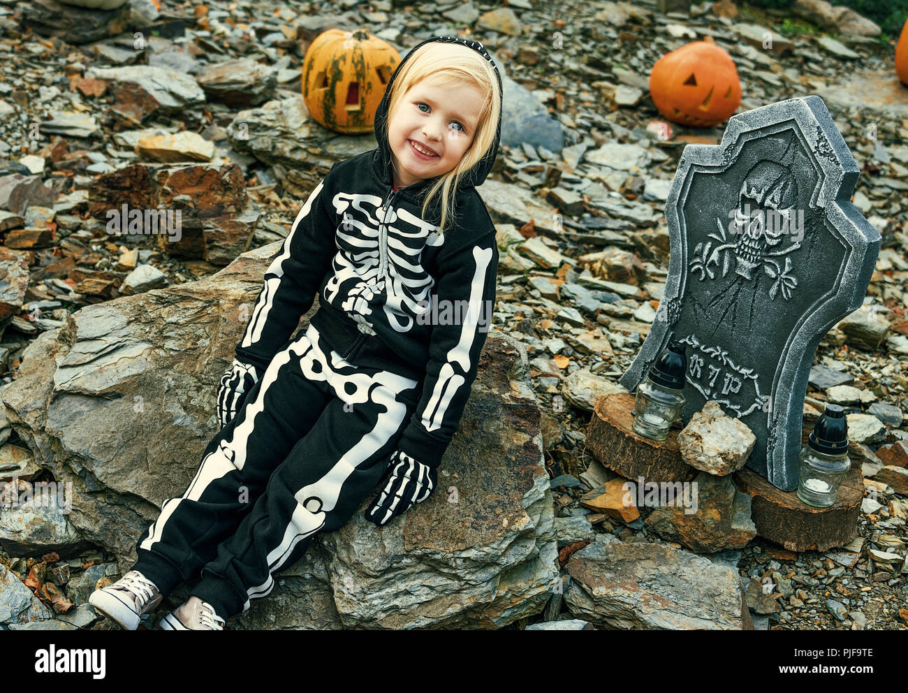 Trick or Treat. child wearing skeleton costume sitting at Halloween ...