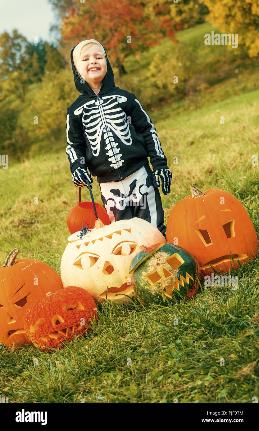 Trick or Treat. happy girl wearing skeleton costume on Halloween at the ...